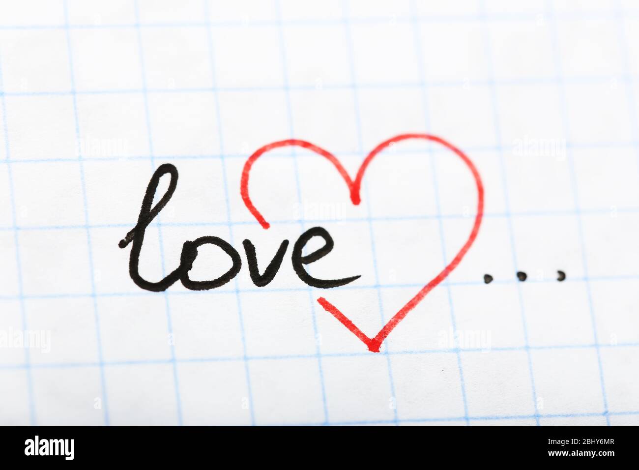 Word LOVE with heart written on sheet of paper background Stock Photo ...