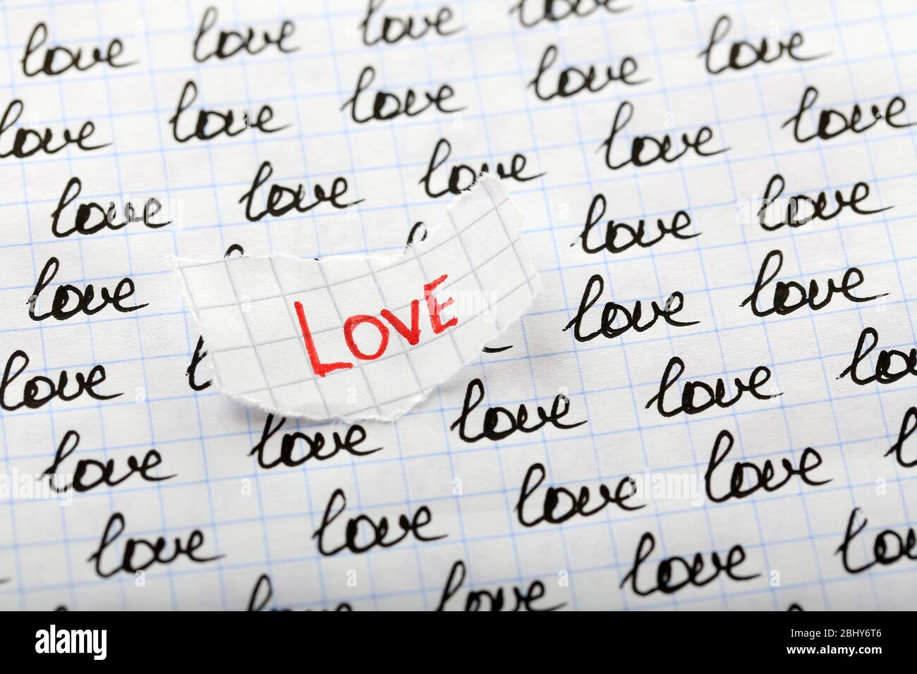 Word LOVE written on torn paper on sheet of paper background Stock ...