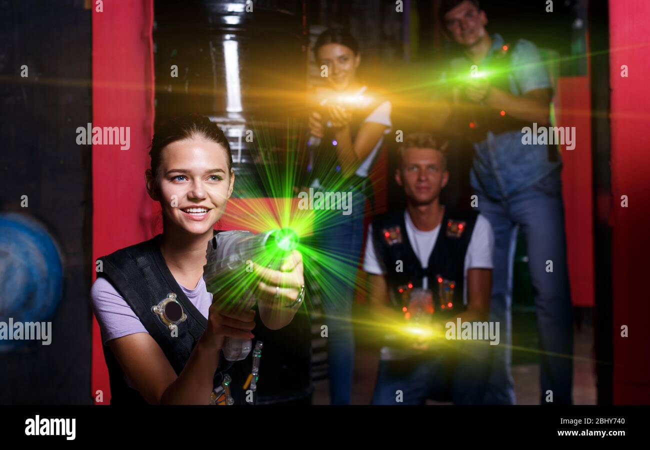 Smiling girl with laser guns took aim and having fun with friends ...
