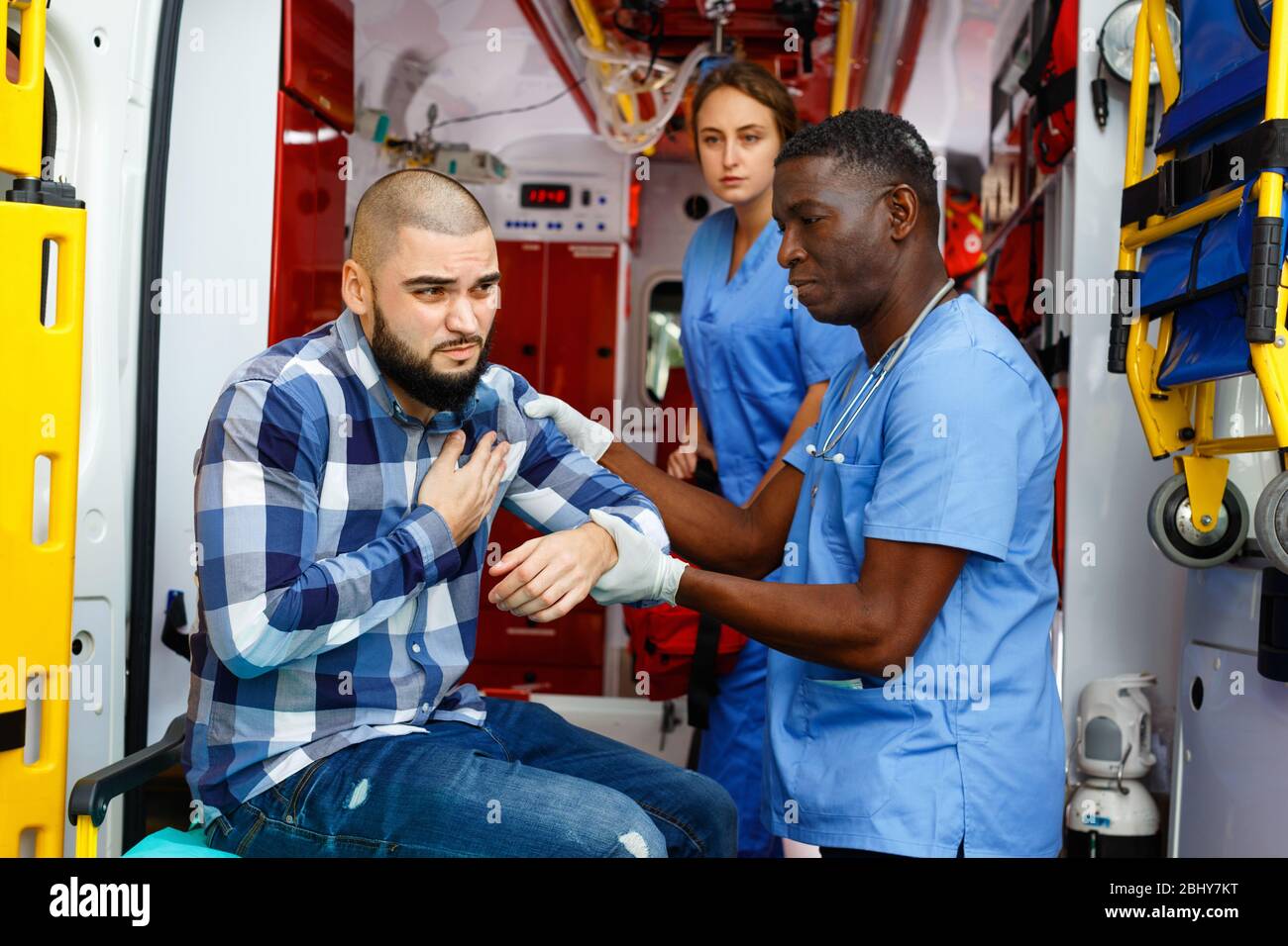 Diligent serious glad positive emergency doctors providing first aid to ...