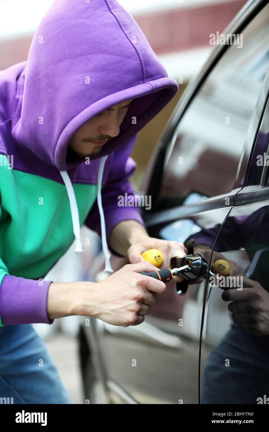 Man burglar stealing car Stock Photo - Alamy