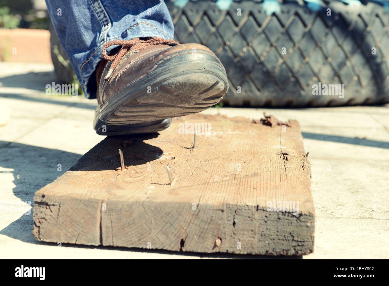 Worker steps on nail outdoors Stock Photo - Alamy