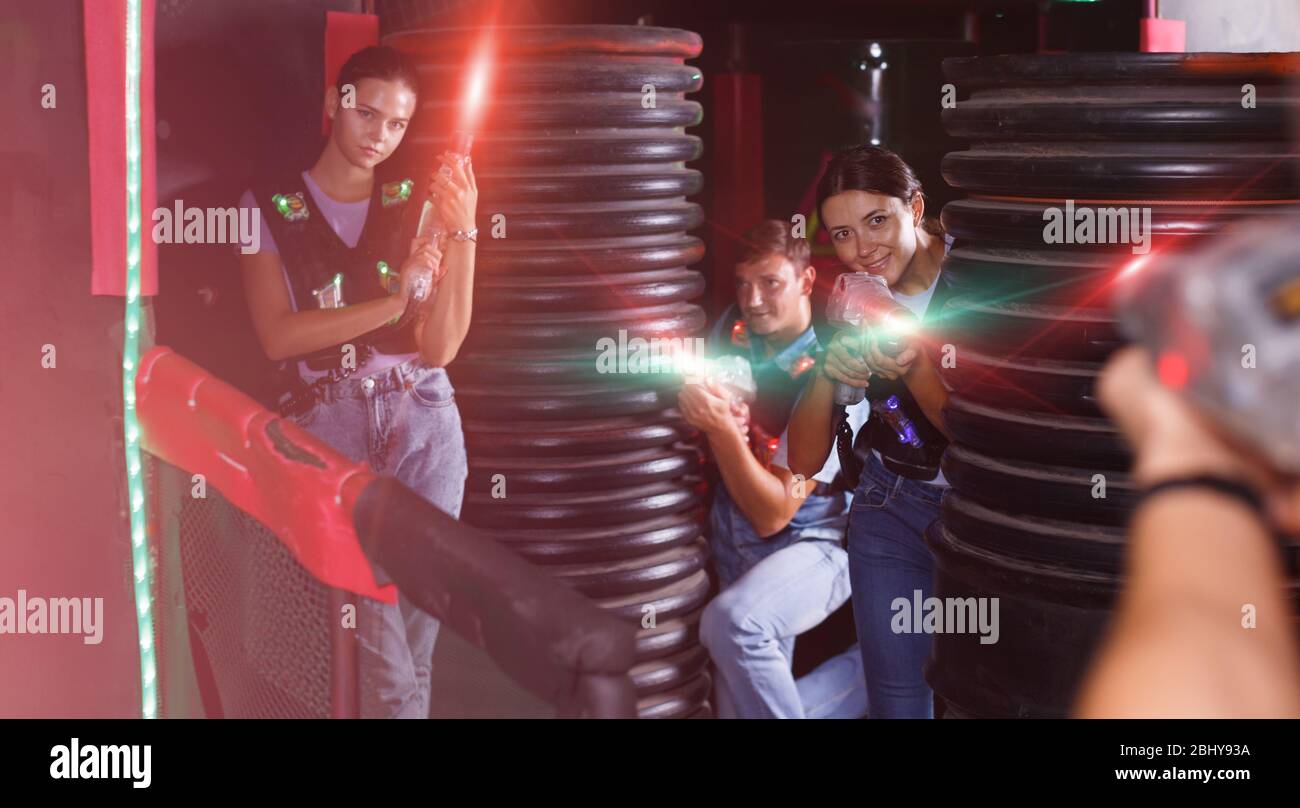 Positive young girls took aim with colored laser guns during laser tag ...