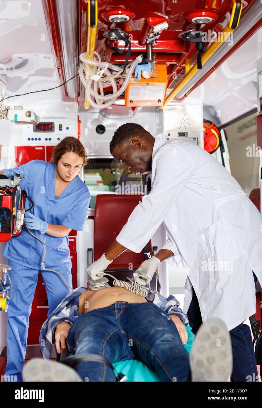 Efficient emergency doctor resuscitating male patient with help of ...