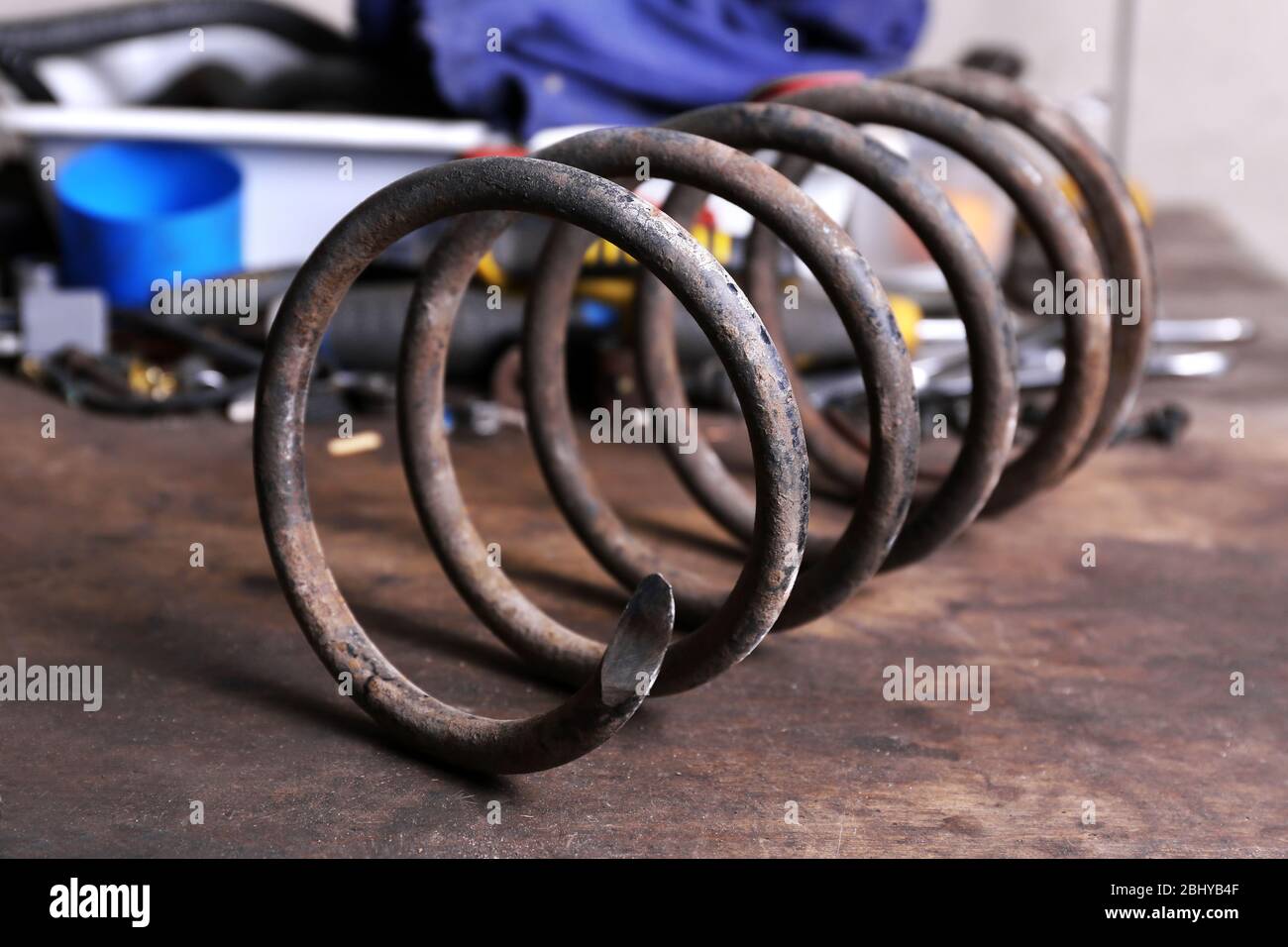 Large metal spring on workplace in garage Stock Photo - Alamy