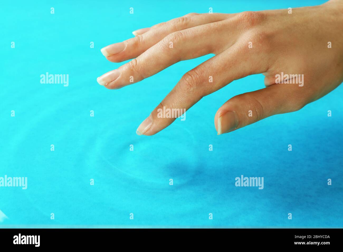 Female hand touching water surface Stock Photo - Alamy