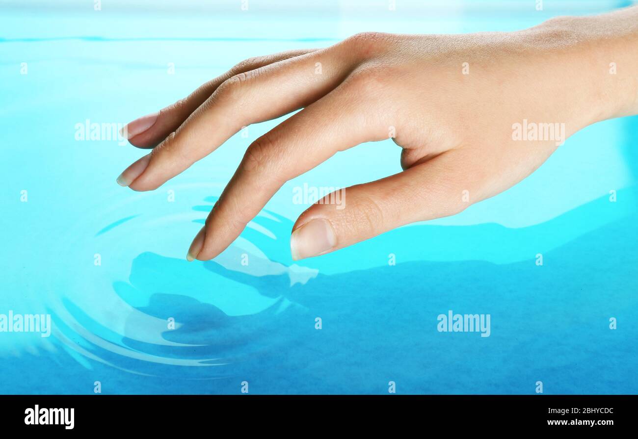 Female hand touching water surface Stock Photo - Alamy