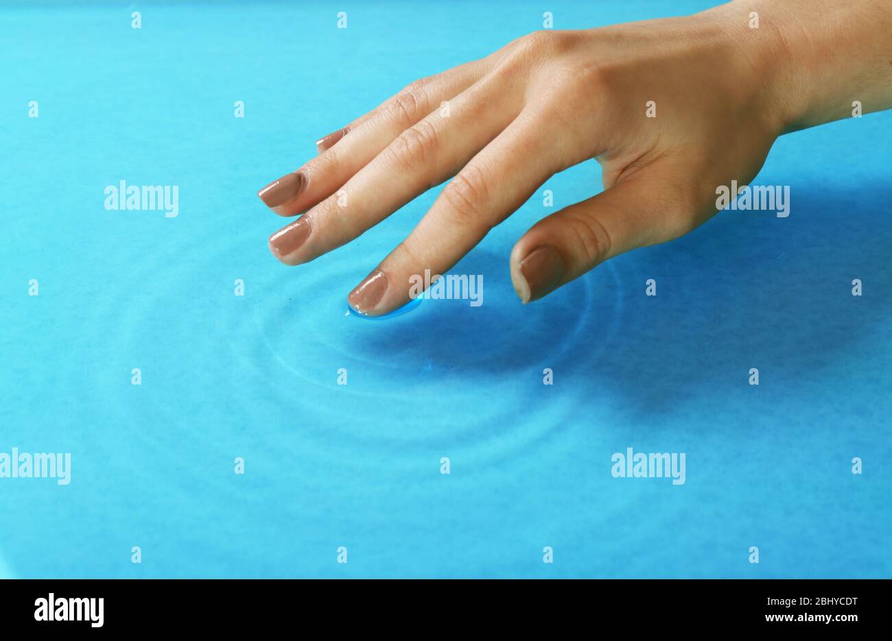 Female hand touching water surface Stock Photo - Alamy