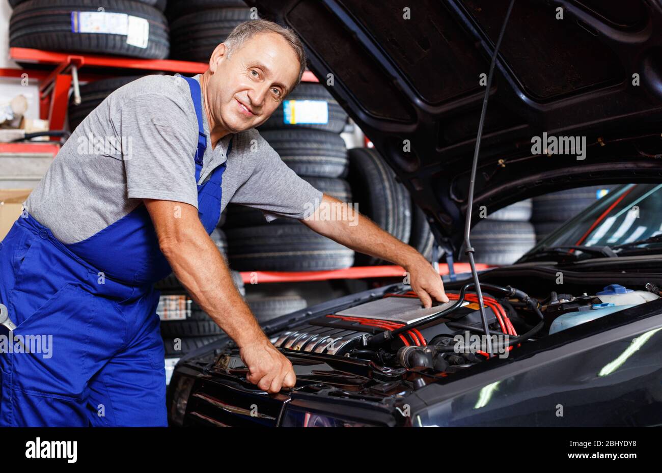 Professional mature glad cheerful smiling man car mechanician repairing ...