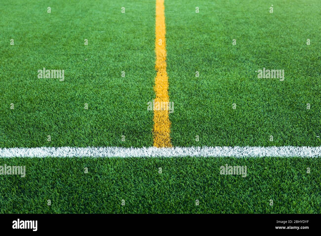 Closeup of green artificial grass turf soccer football field with white ...