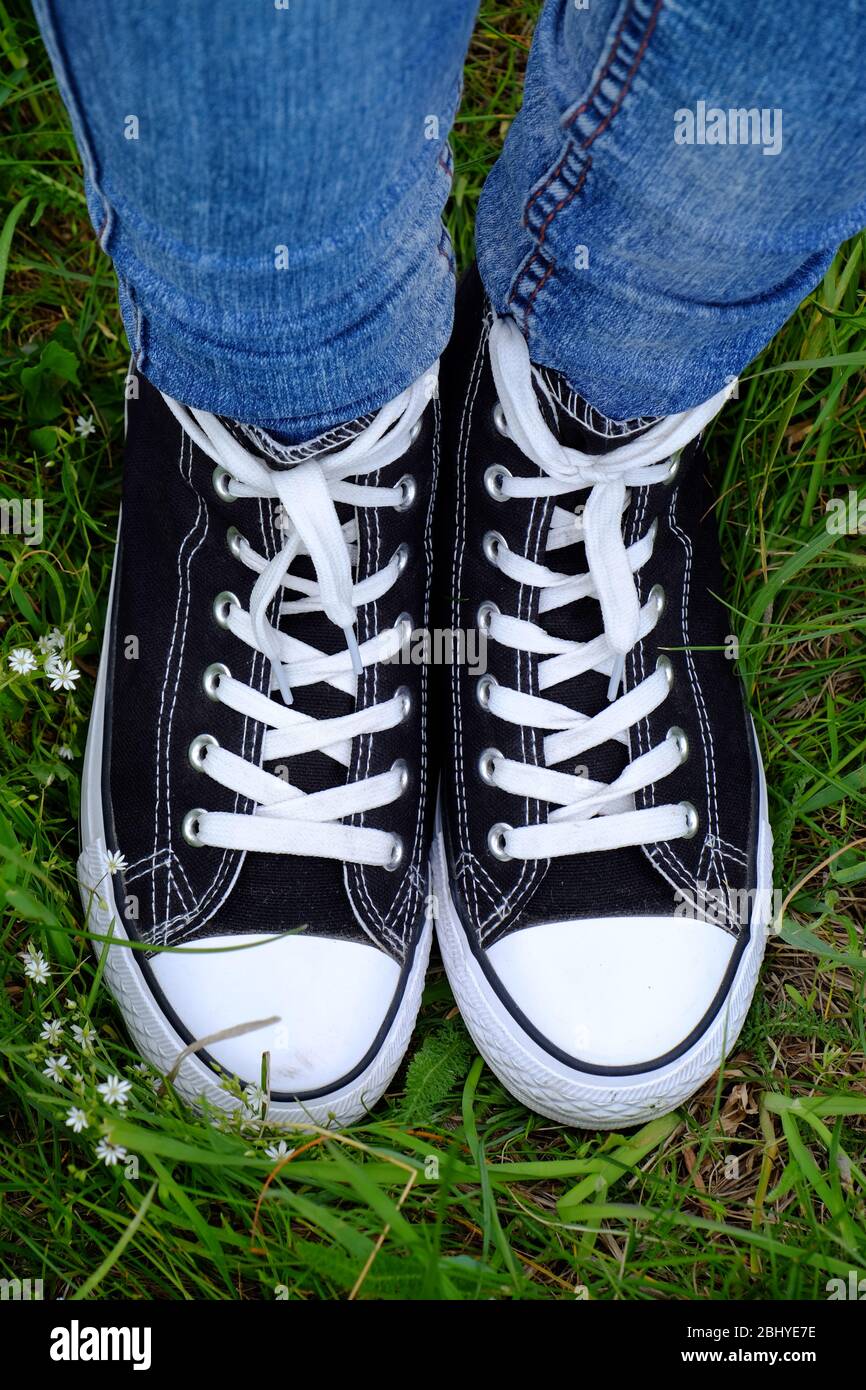 Female feet in gumshoes on green grass background Stock Photo - Alamy