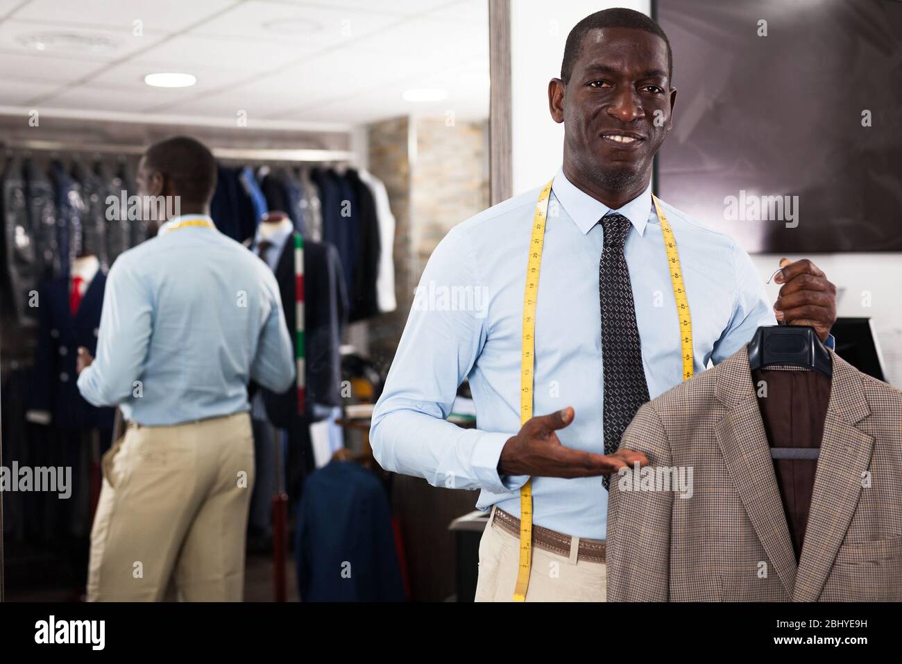 Male customer demonstrating his choice of suit in shop Stock Photo - Alamy