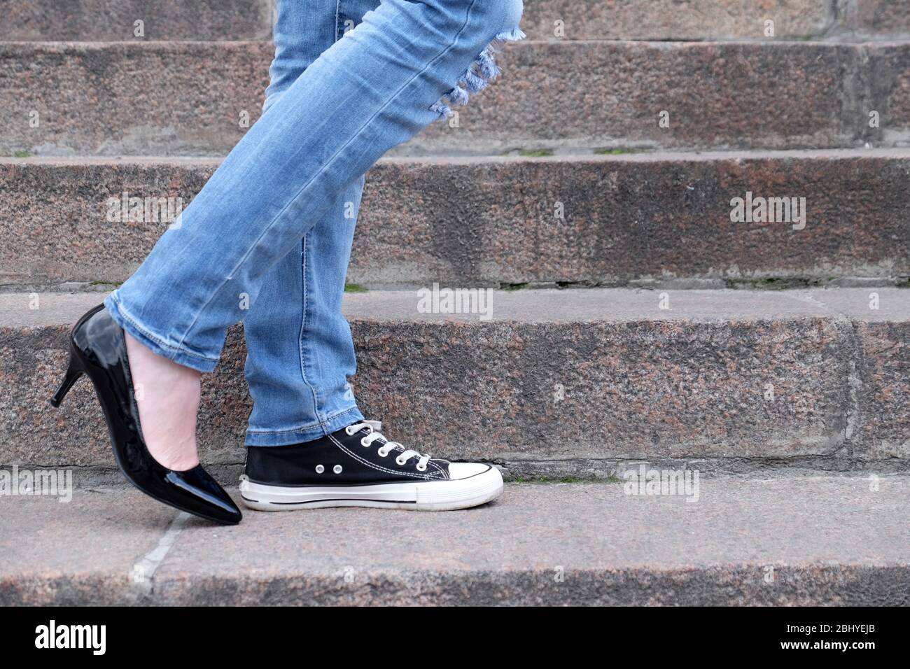 Female feet in different shoes on stone stairs Stock Photo - Alamy