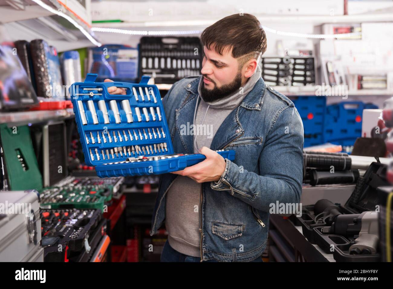 Male is standing with new ratchet in tools store Stock Photo - Alamy