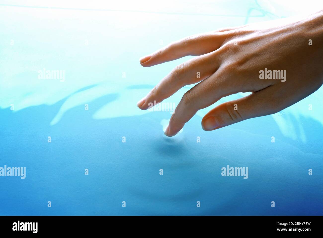 Finger touches water close up Stock Photo - Alamy