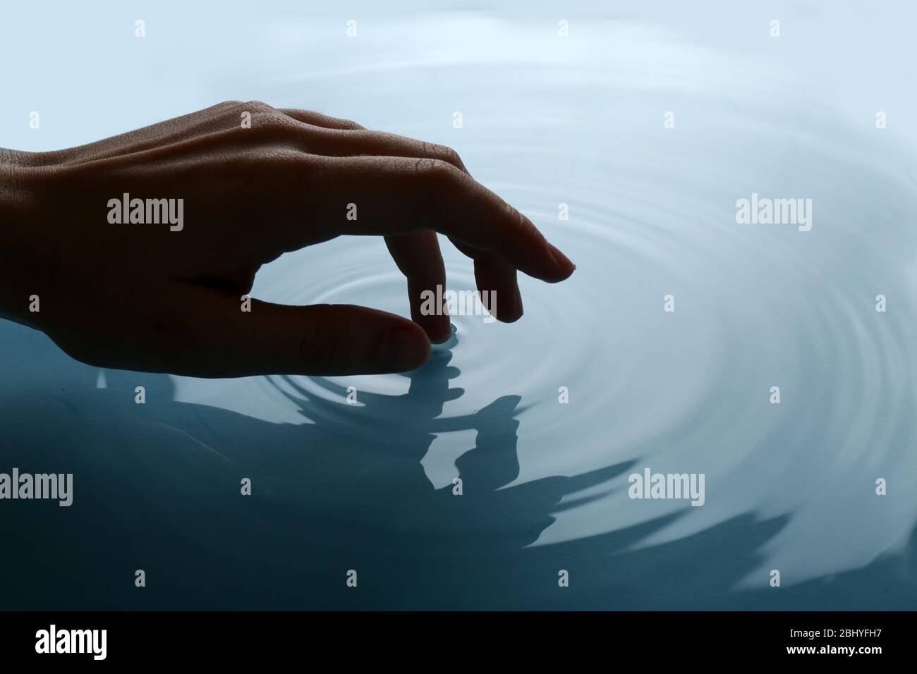 Finger touches water close up Stock Photo - Alamy