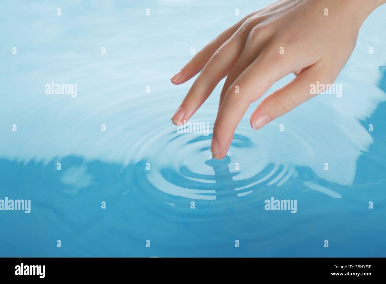 Finger touches water close up Stock Photo - Alamy