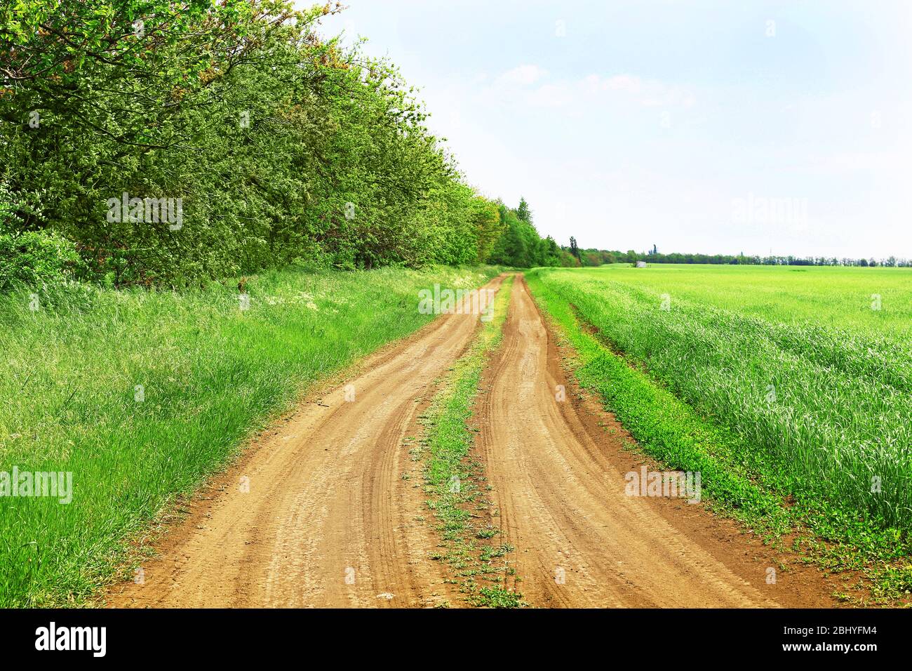 Country road over blue sky background Stock Photo - Alamy