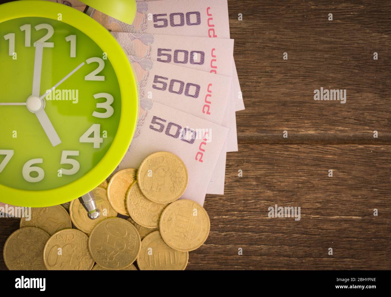 clock with money on desk. concept of time is money. view from above ...