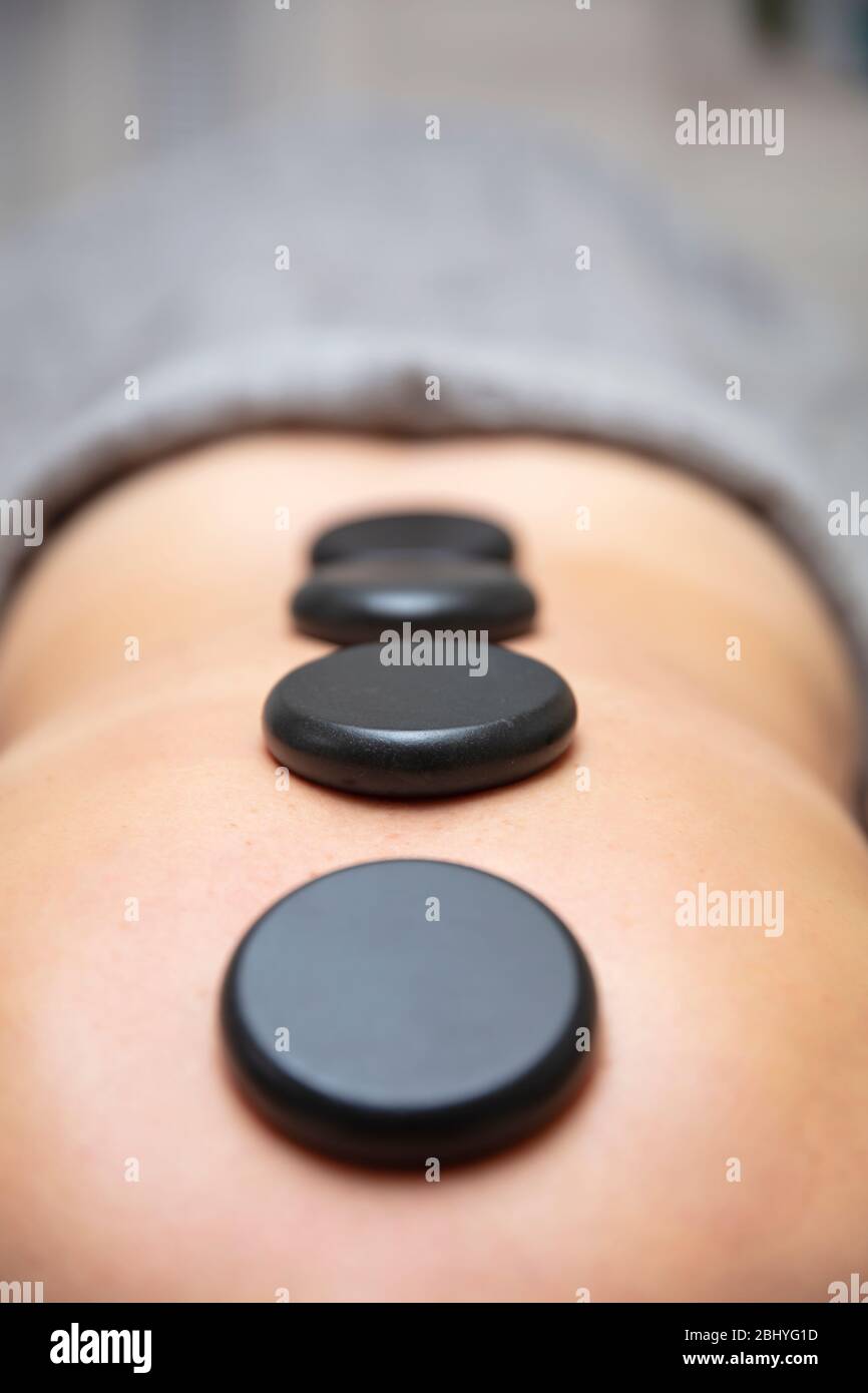 Young woman have a health spa relaxing stone therapy with hot volcanic ...