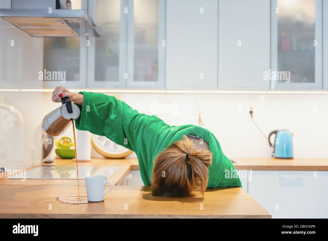 Tired woman sleeping on the table in the kitchen at breakfast. Trying ...