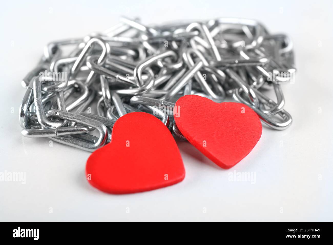 Two red hearts with metal chain isolated on white Stock Photo - Alamy