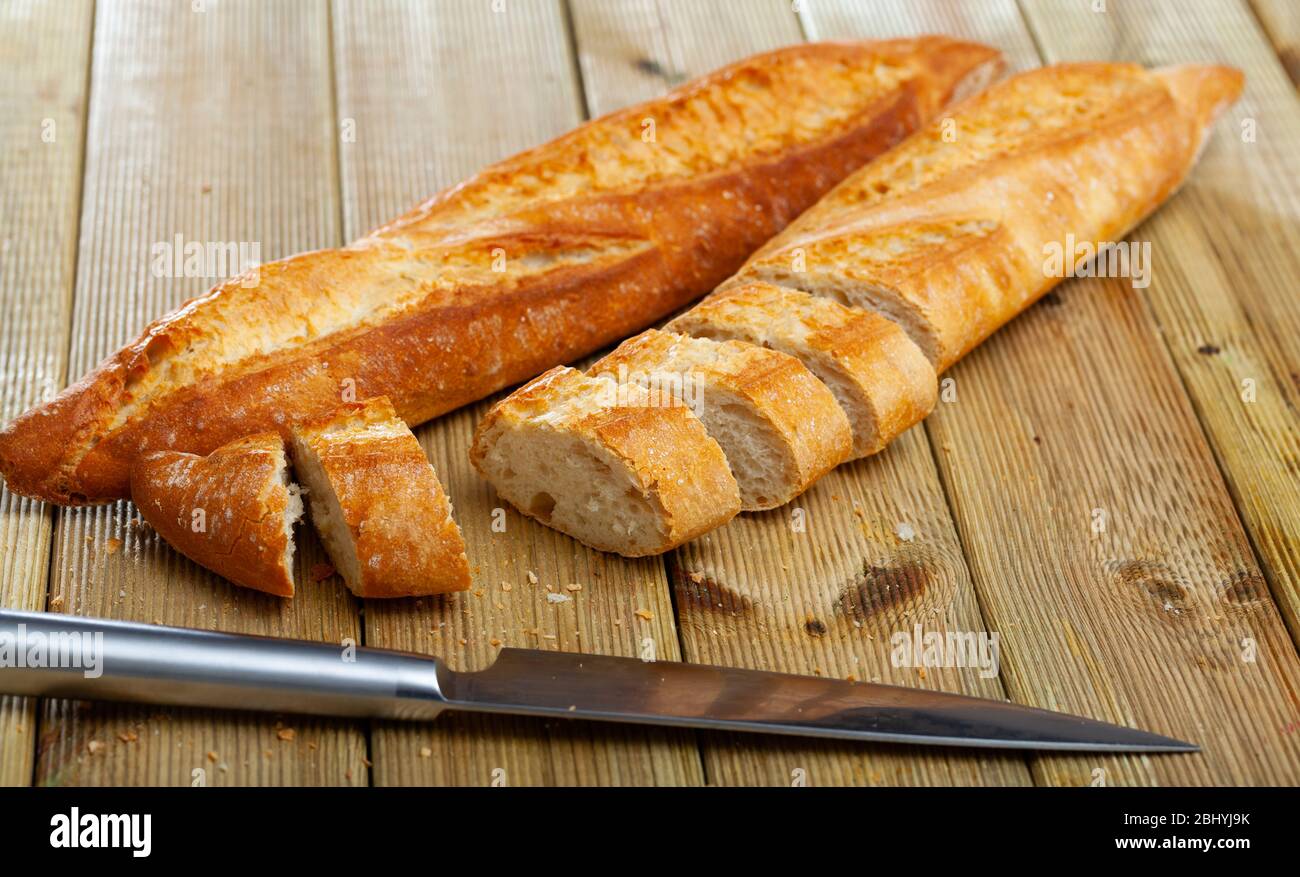 Sliced freshly baked French baguette with appetizing crispy crust on ...