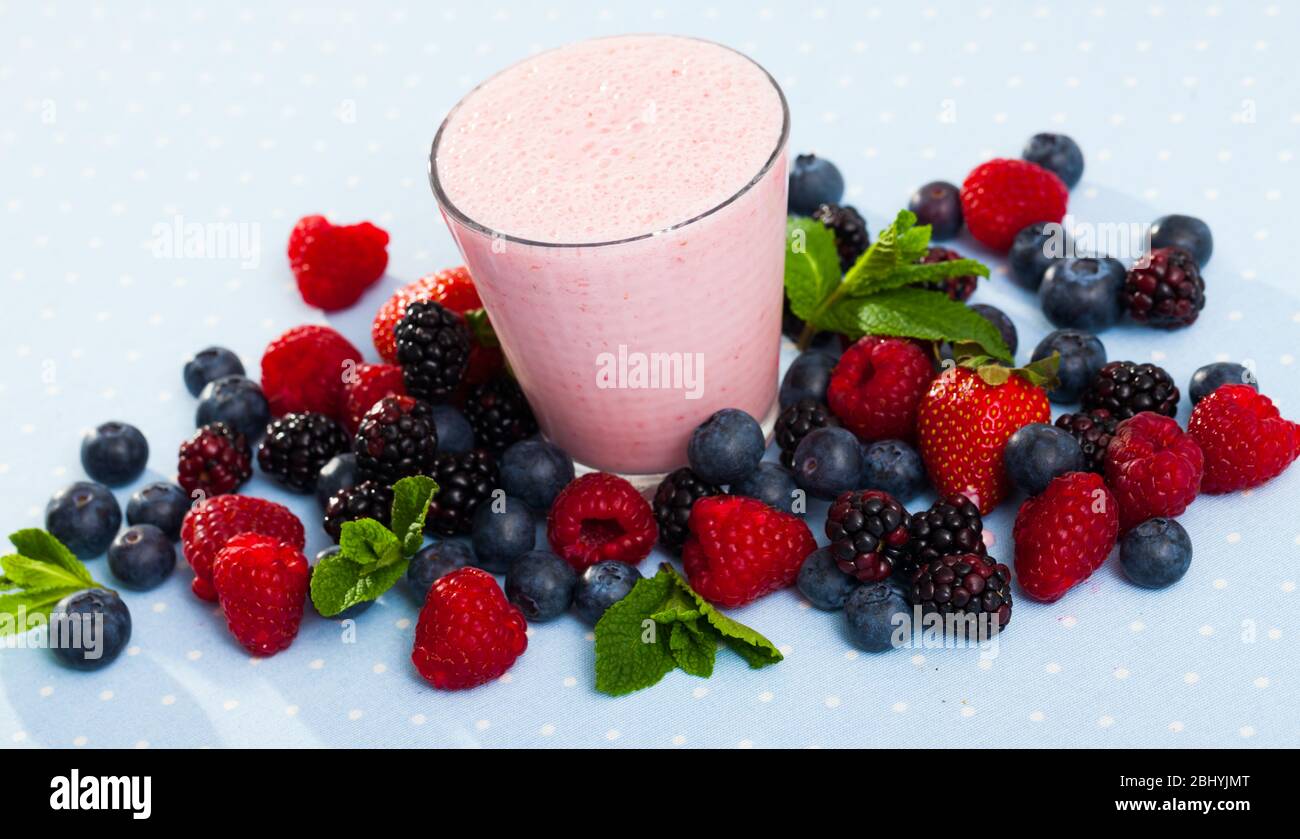 Healthy vitamin milkshake with mix of ripe berries and mint leaves ...