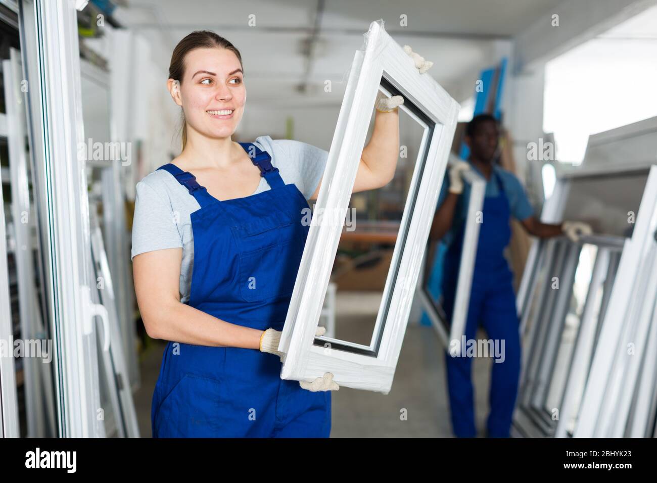 Female master is working with window frame in the window workshop Stock ...