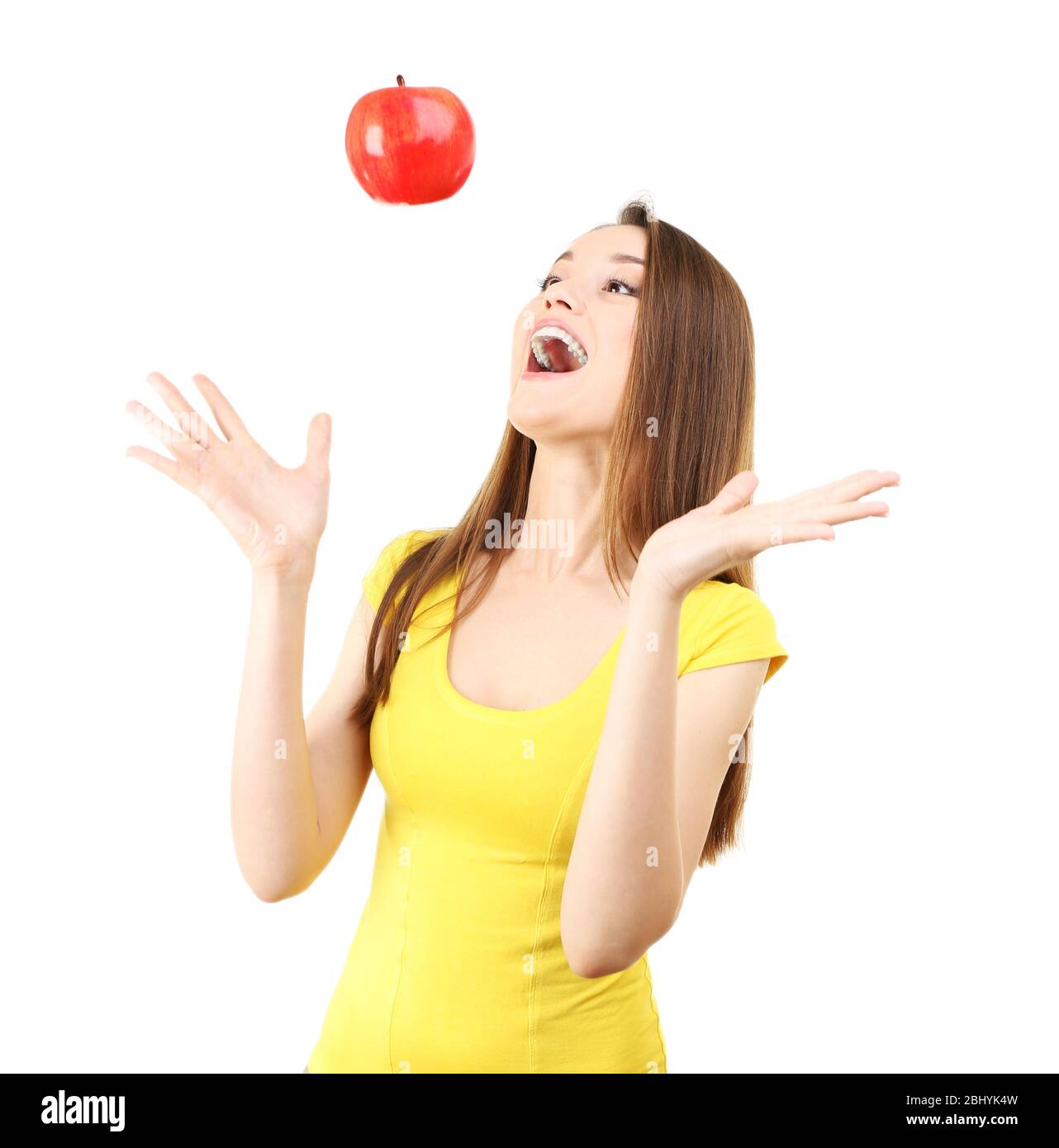 Healthy young woman throwing up red apple isolated on white Stock Photo ...
