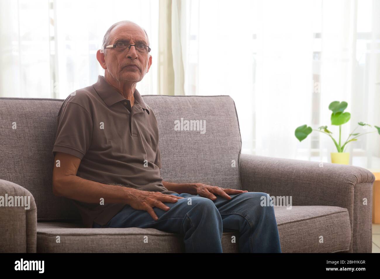 Portraits of a senior man sitting on couch at home Stock Photo - Alamy
