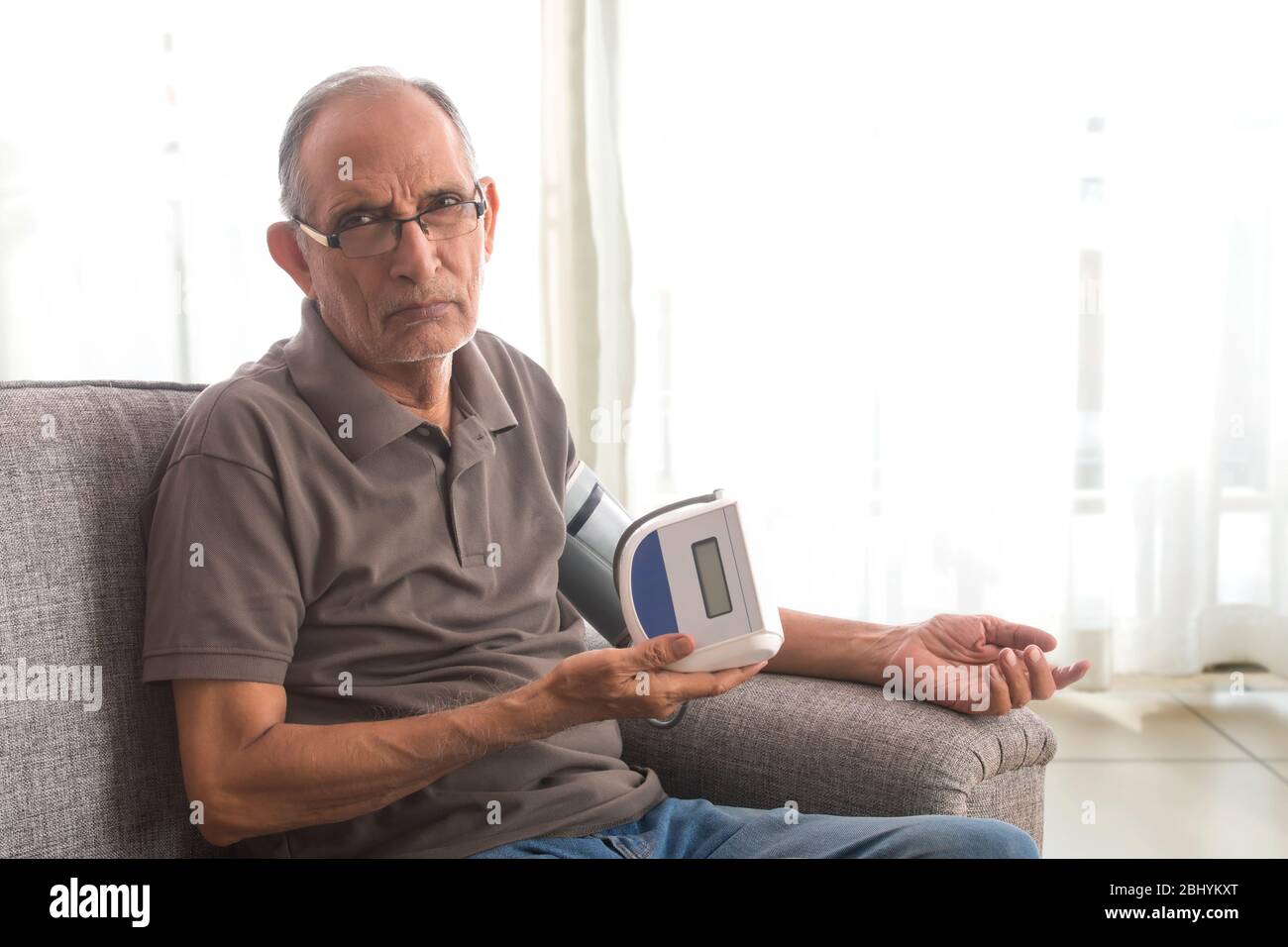 Senior man taking his blood pressure test at home. (Health and fitness ...