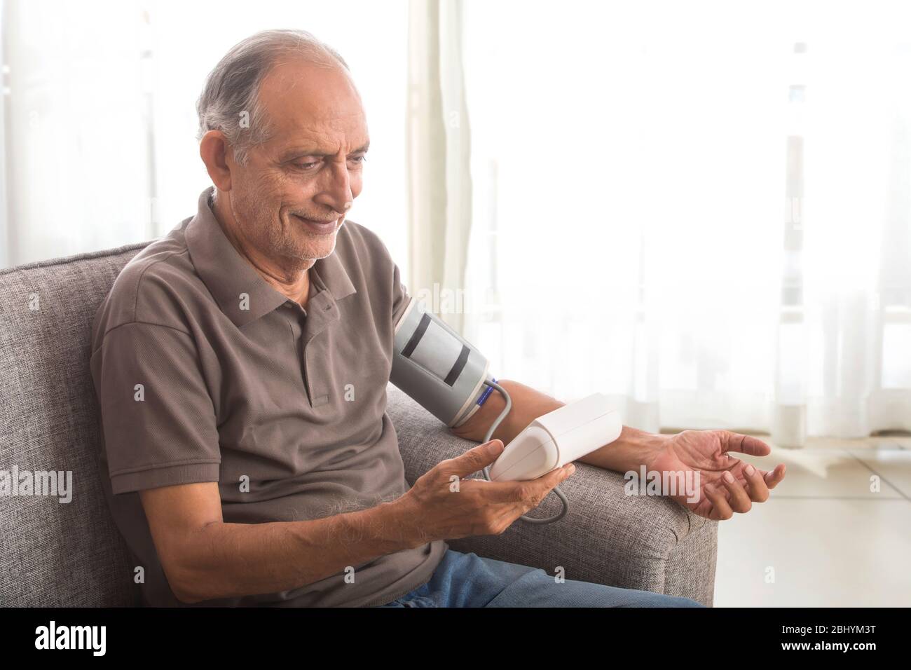 Senior man taking his blood pressure test at home. (Health and fitness ...