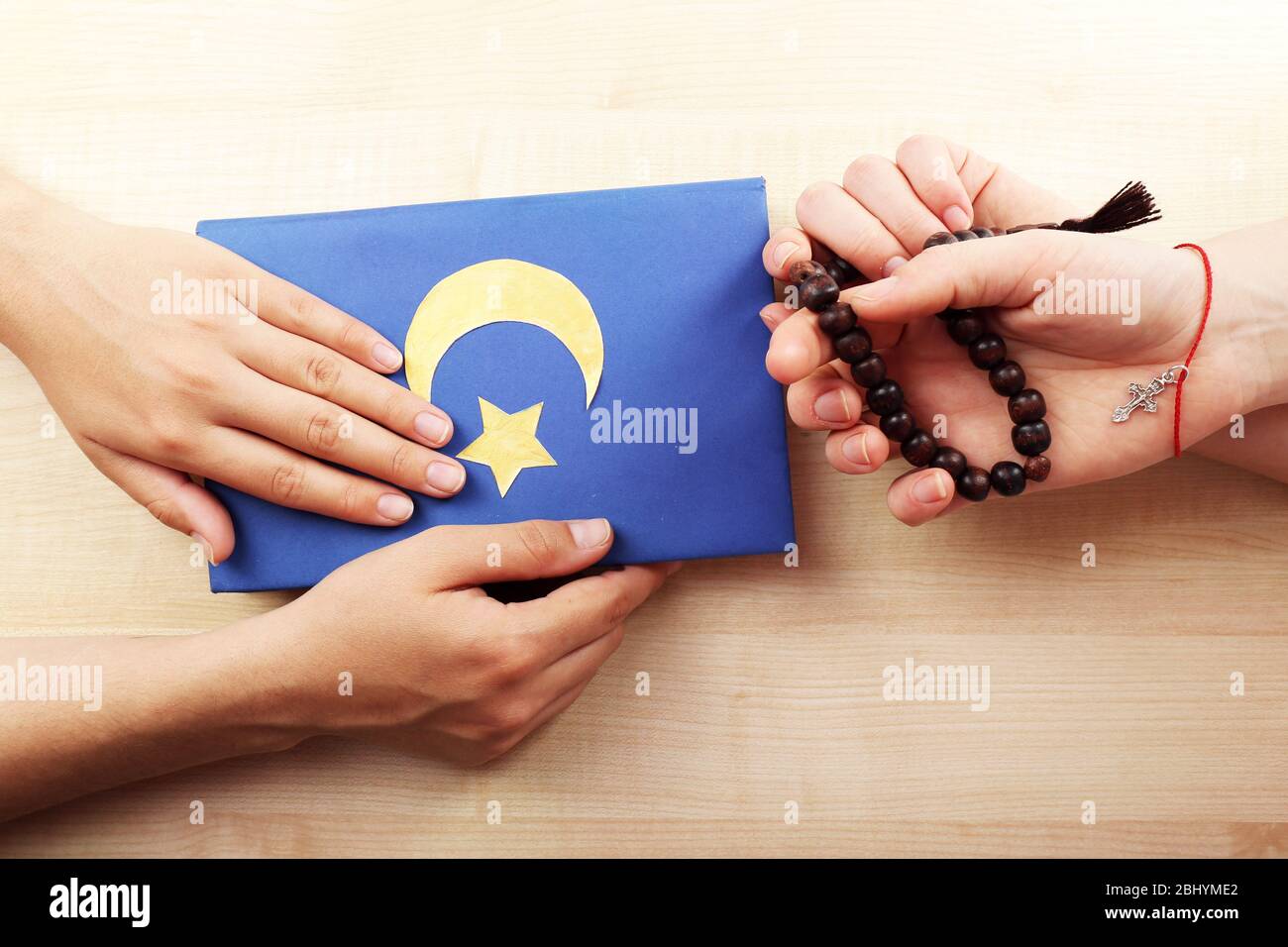 Hands of two friends with different religions symbols Stock Photo - Alamy