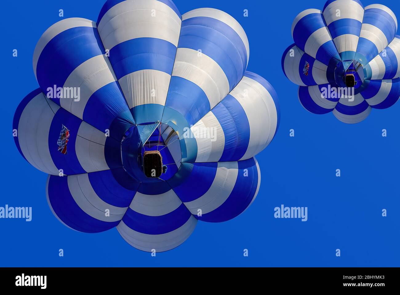 Hot air balloon ascending into the blue sky directly from below Stock ...