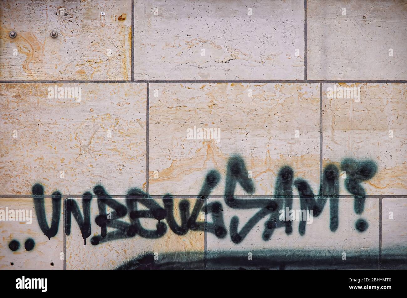 Scribbling on a wall to read the German words UNBEUGSAM Stock Photo - Alamy