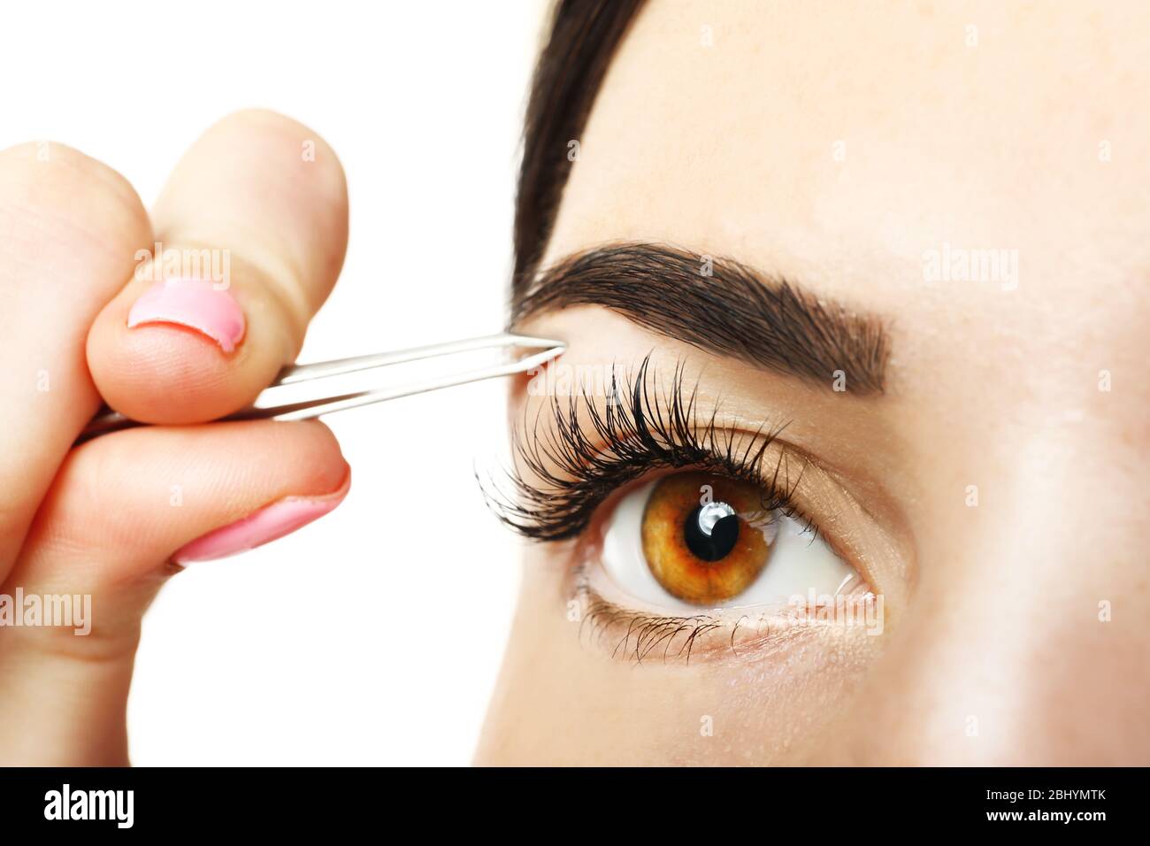 Young woman plucking eyebrows with tweezers close up Stock Photo - Alamy