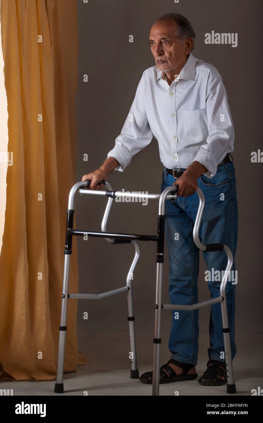 Senior man standing with the help of a walker. (Health and fitness ...