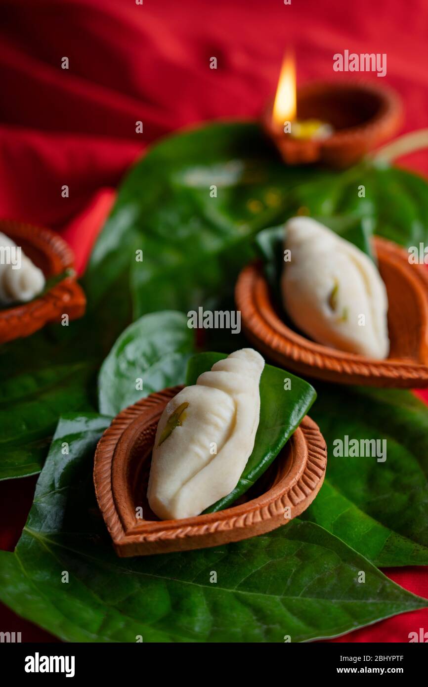 Shankh shaped sondesh arranged beautifully on betel leaves Stock Photo ...