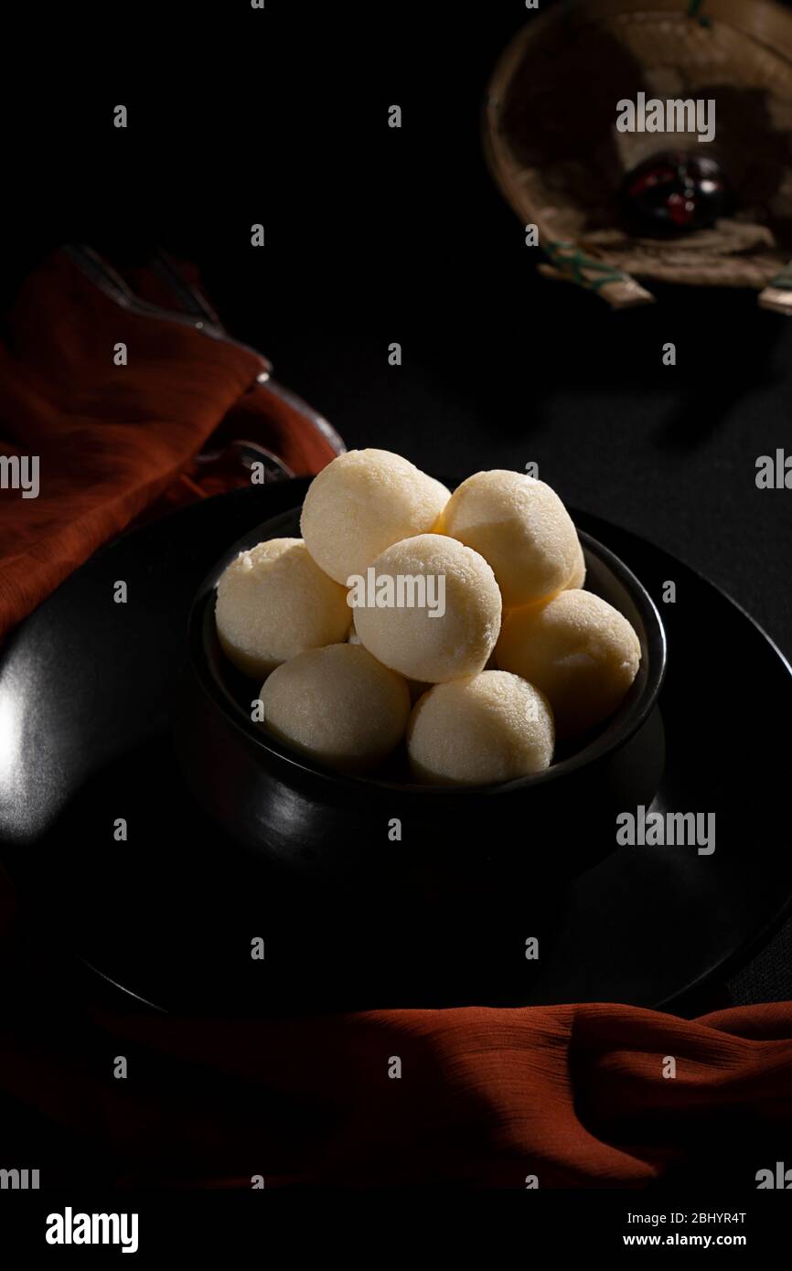 Delicious white rasgullas kept in a black bowl Stock Photo - Alamy