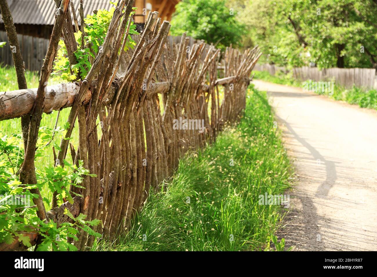 Fence of wooden sticks along road Stock Photo - Alamy