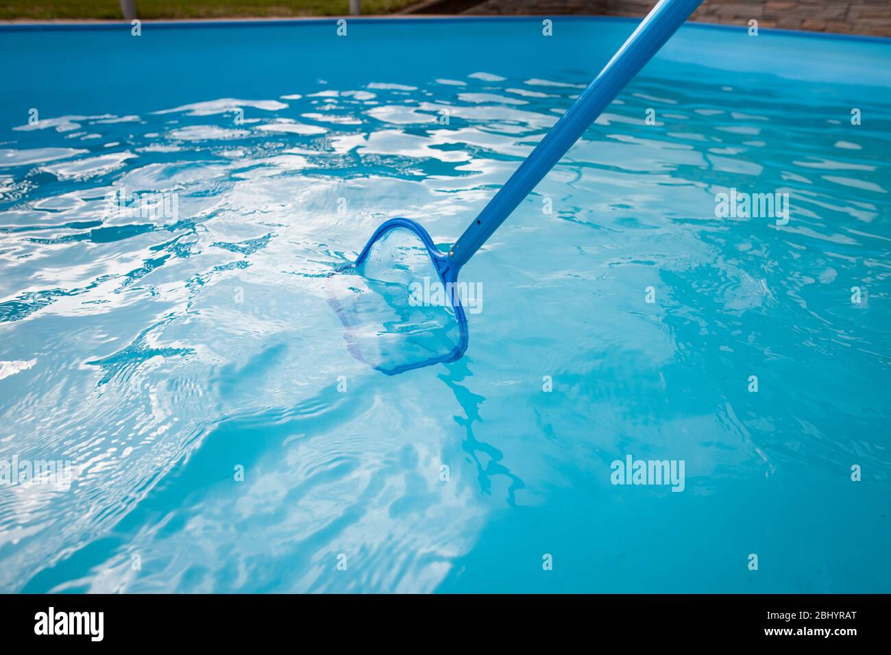 Young man hands cleaning pool by net of the dust, maintenance, clearing ...
