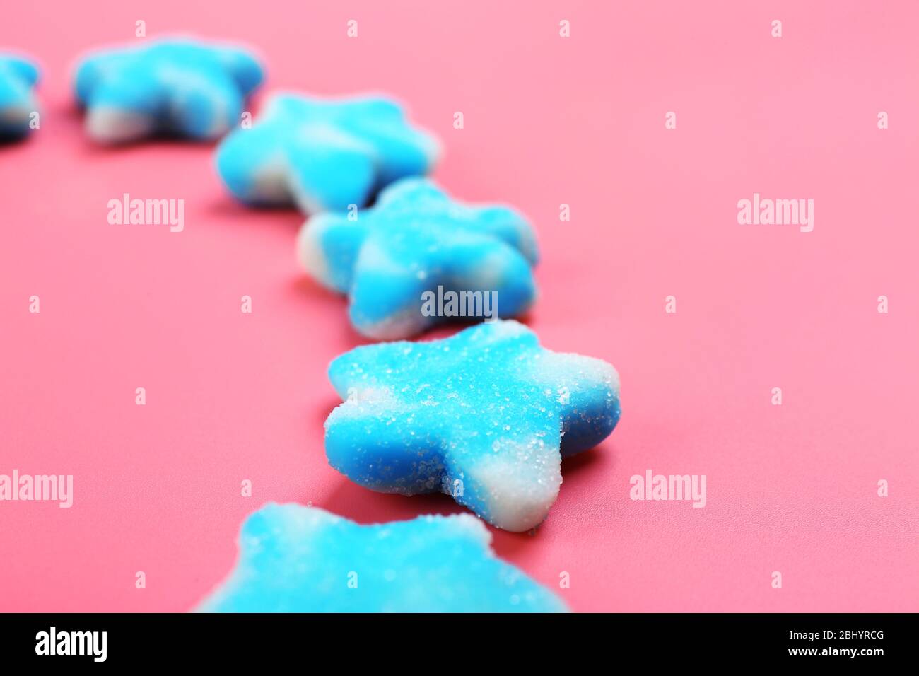 Blue candies in shape of stars on pink background Stock Photo - Alamy