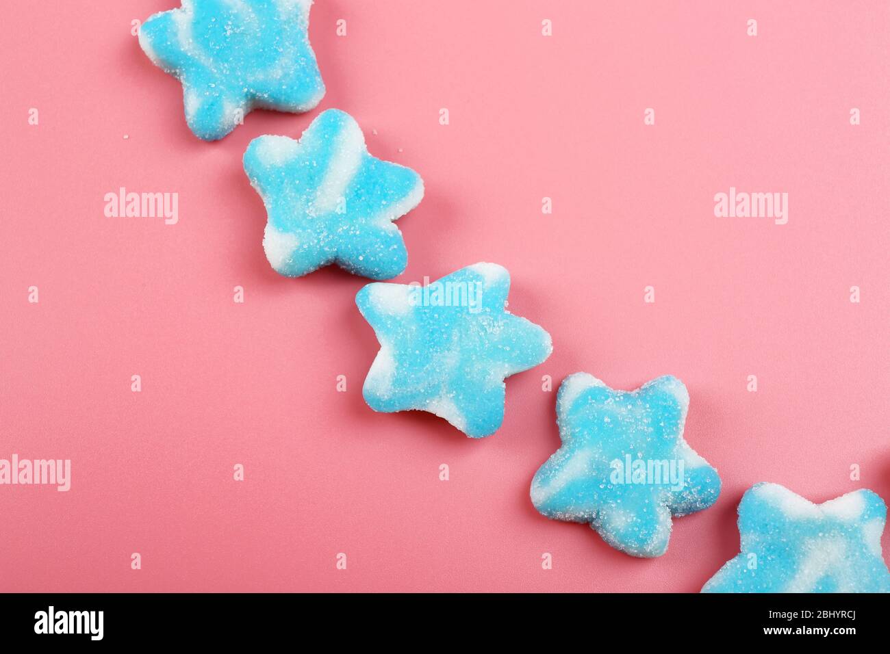 Blue candies in shape of stars on pink background Stock Photo - Alamy