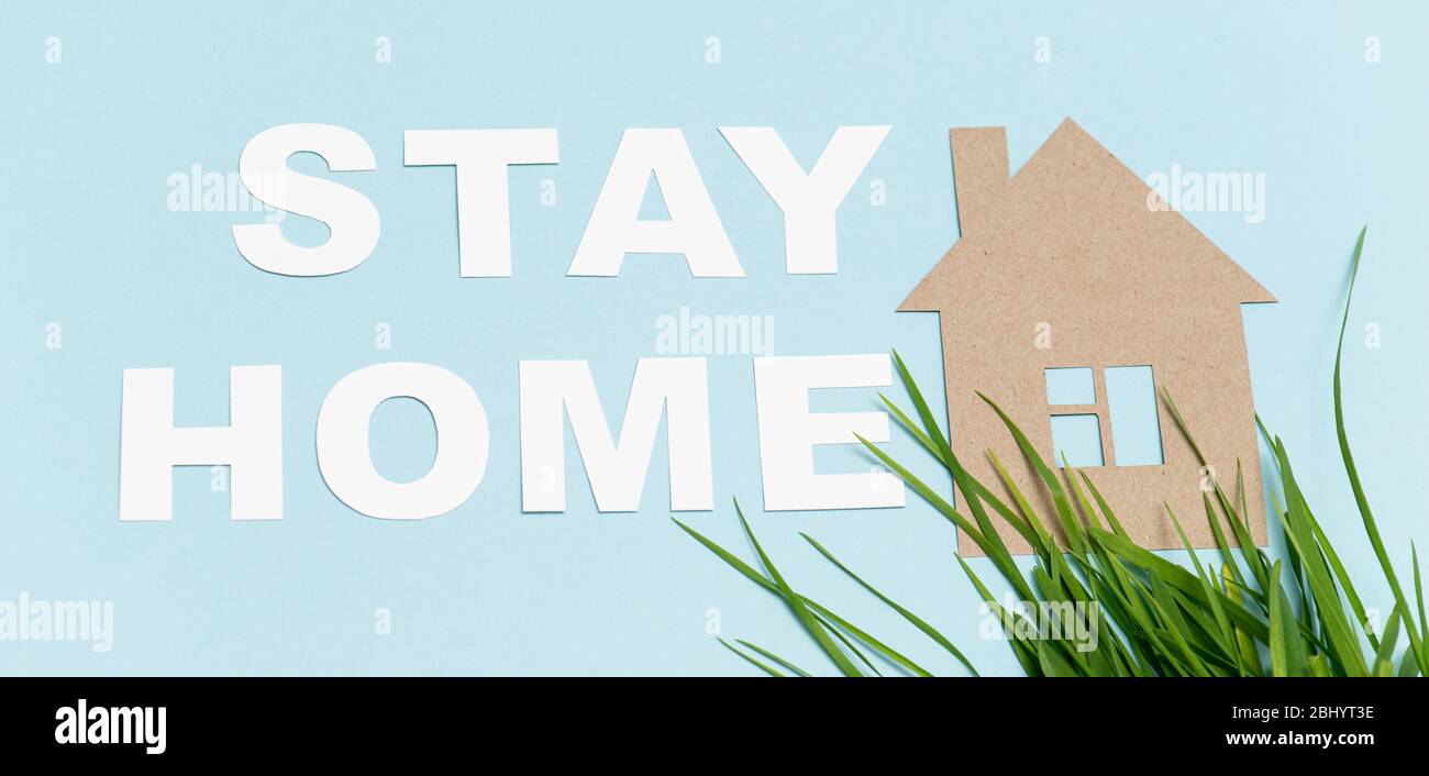 Stay home message laid on a blue surface along with house shape and ...