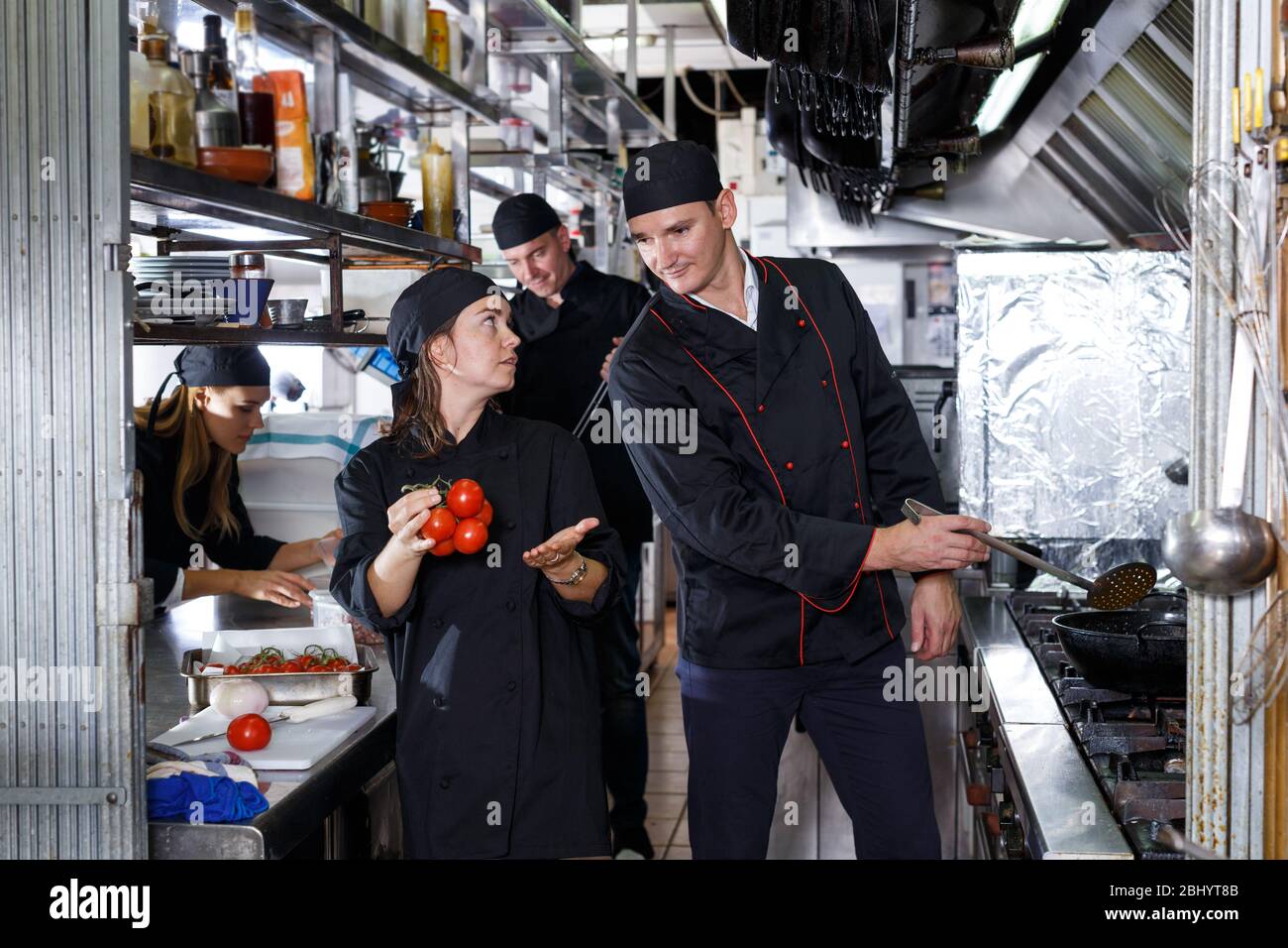 Positive cooks in process of working in kitchen of restaurant Stock ...