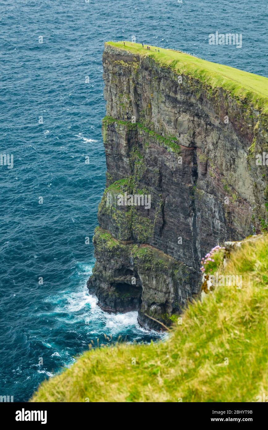 High cliffs over the ocean with small tourists Stock Photo - Alamy
