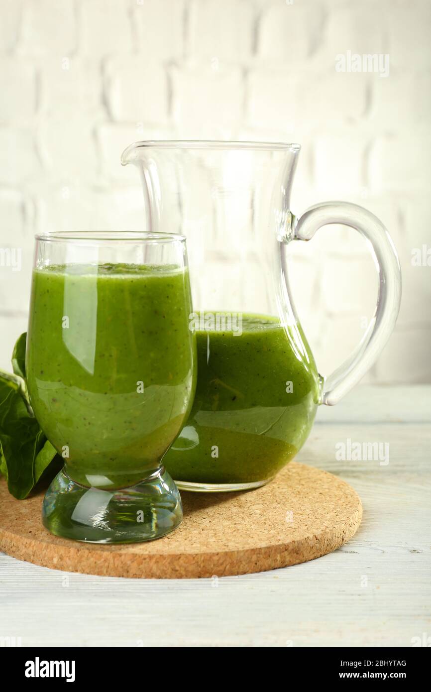Healthy green smoothie with spinach on wooden table on white wall ...