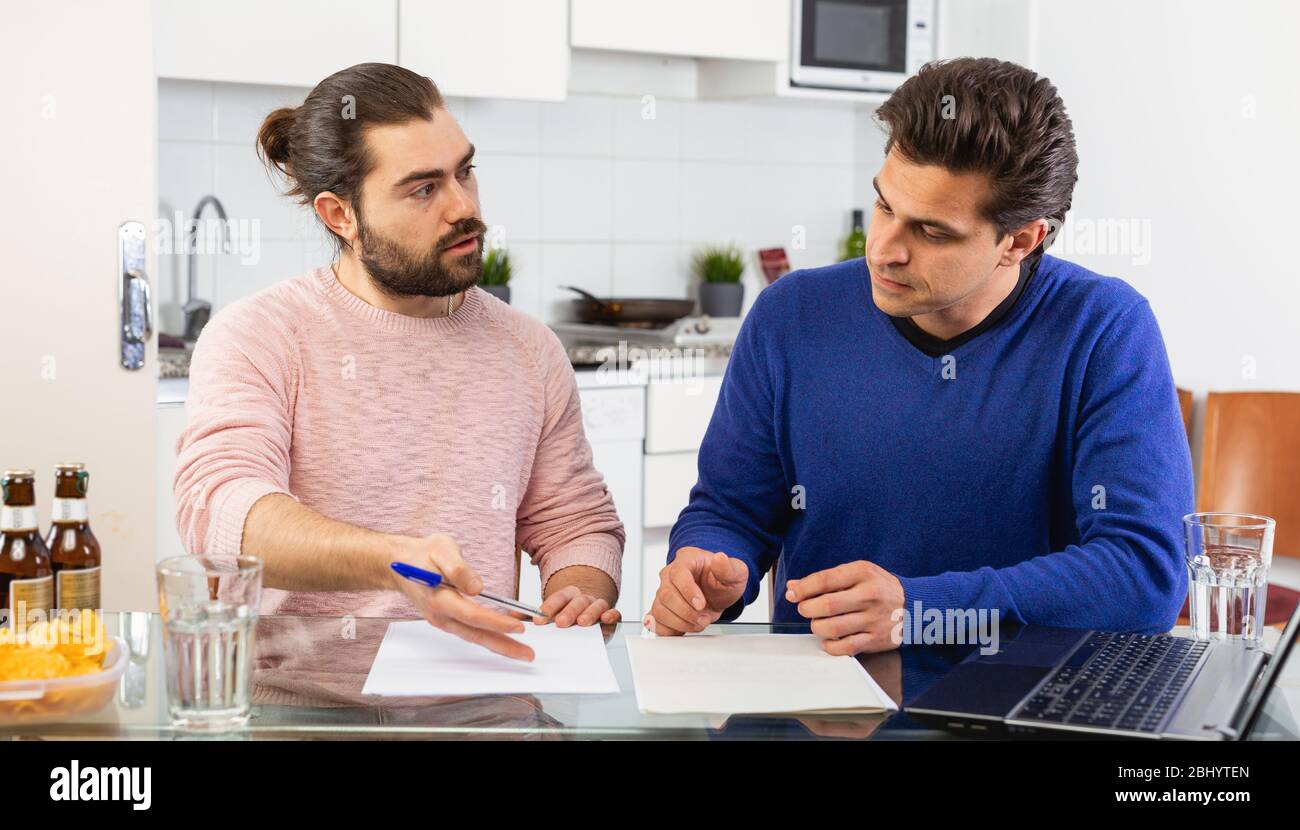 Man having problems with some documents; worriedly discussing with ...