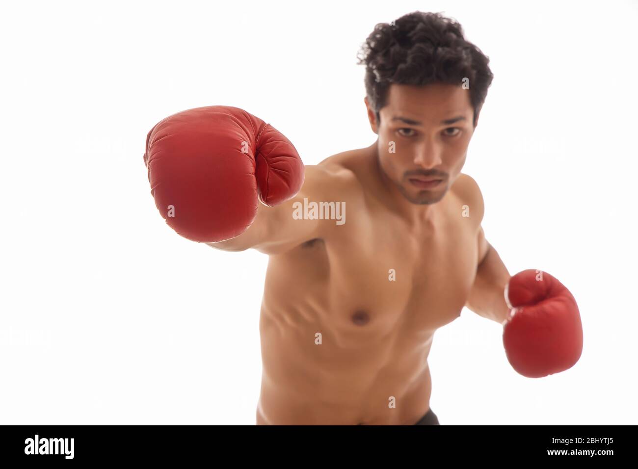 Man throwing punch in the air while wearing boxing gloves in front of a ...